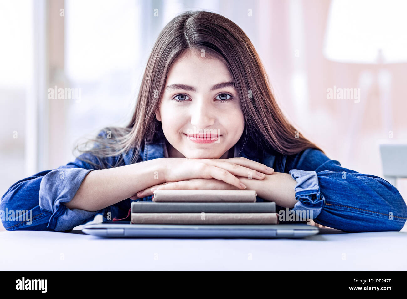 Glad happy girl studying with stock of books Stock Photo - Alamy