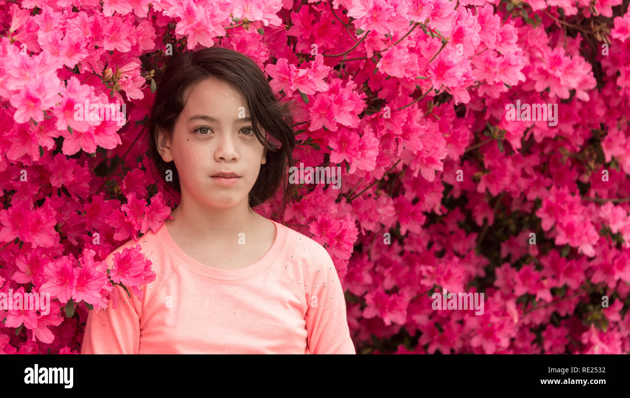 Young girl standing in front of pink azaleas Stock Photo - Alamy