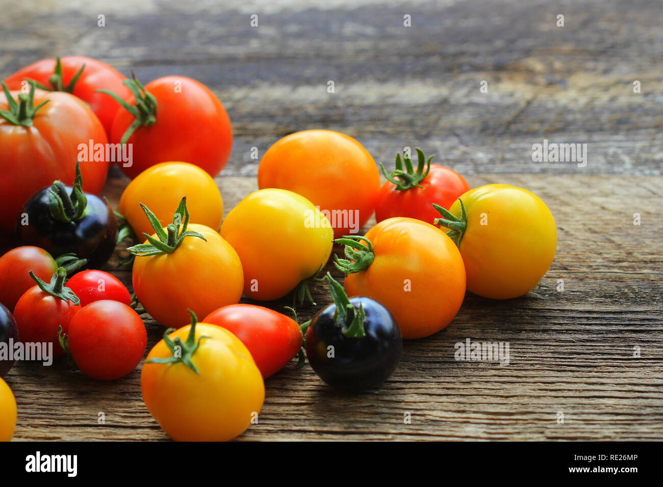 Heirloom variety tomatoes on rustic table. Colorful tomato - red,yellow ...