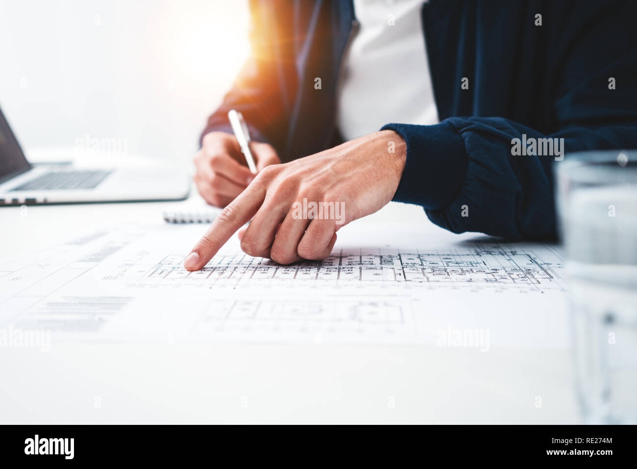 Close-up of hands architect uses laptop and building blueprint on ...
