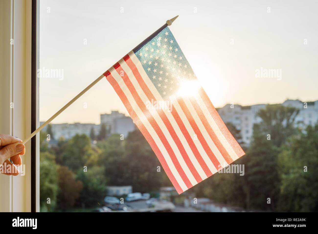 American flag from the window on sunset background Stock Photo - Alamy