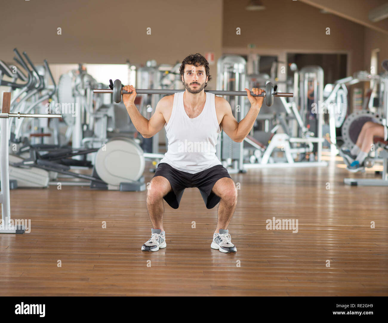 Man doing squats in a gym Stock Photo - Alamy