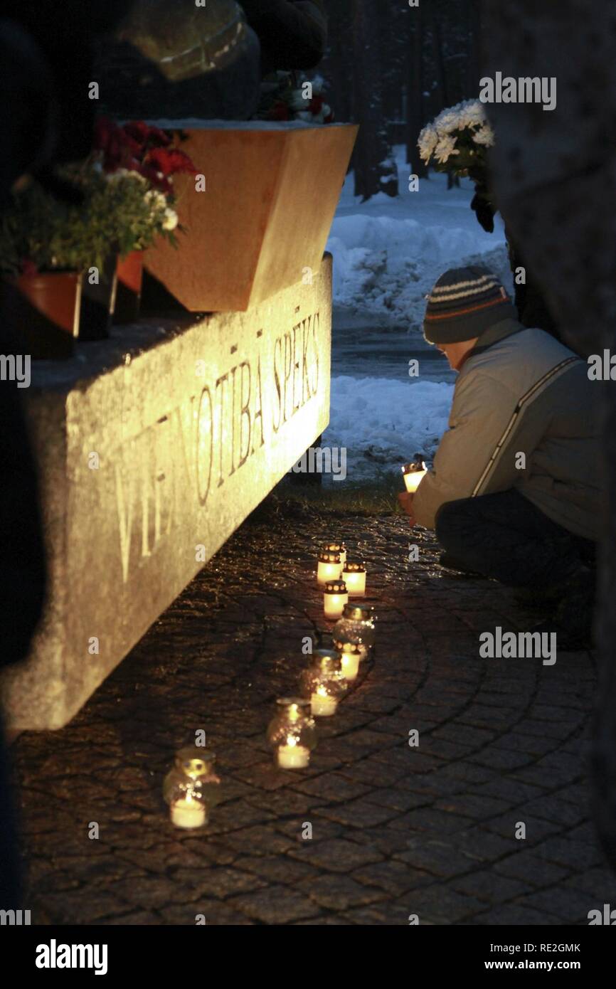 CAMP ADAZI, Latvia – A Latvian child places a memorial candle at the ...
