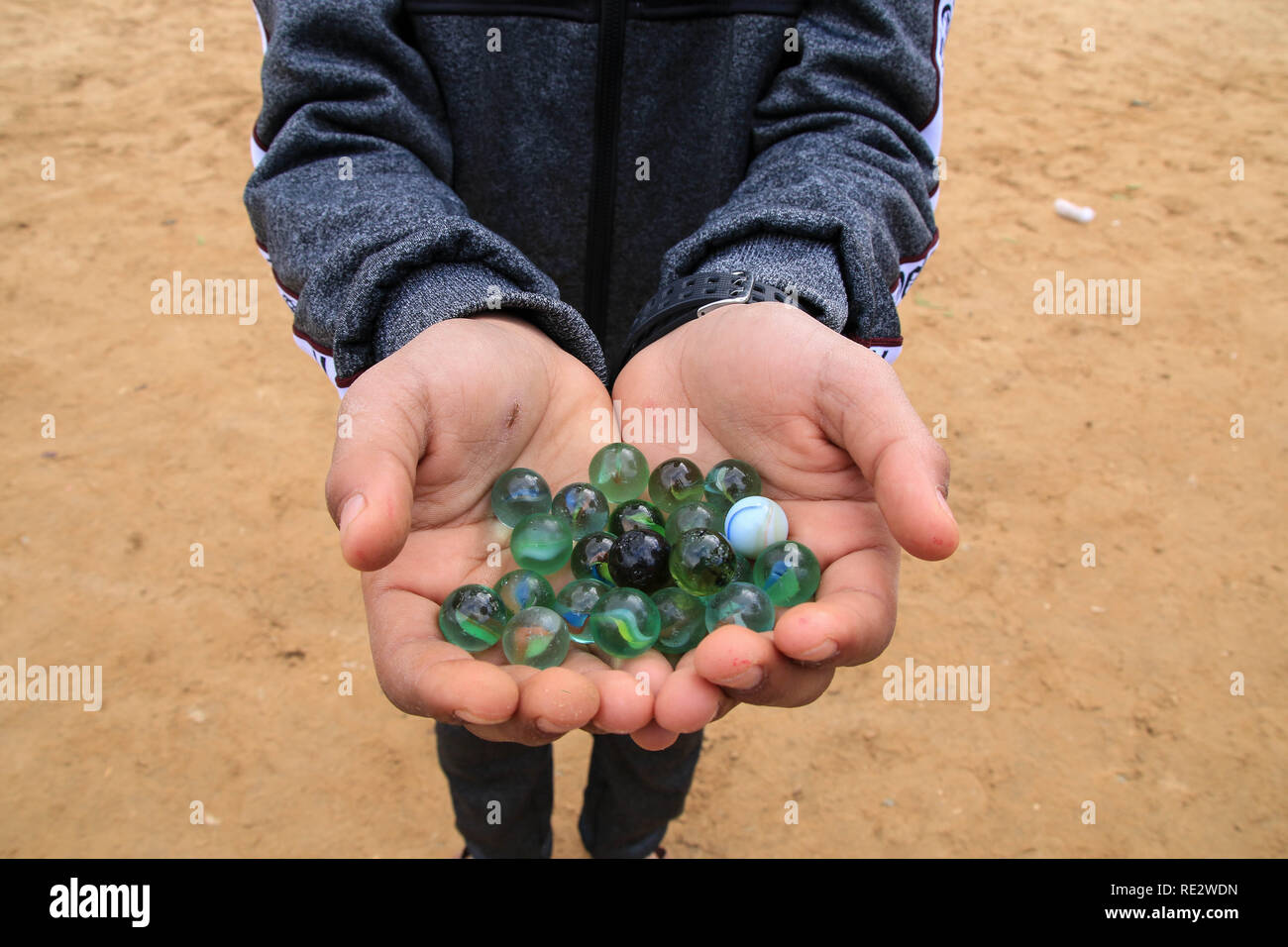 A children seen showing small balls while playing the 'marbles', one of ...
