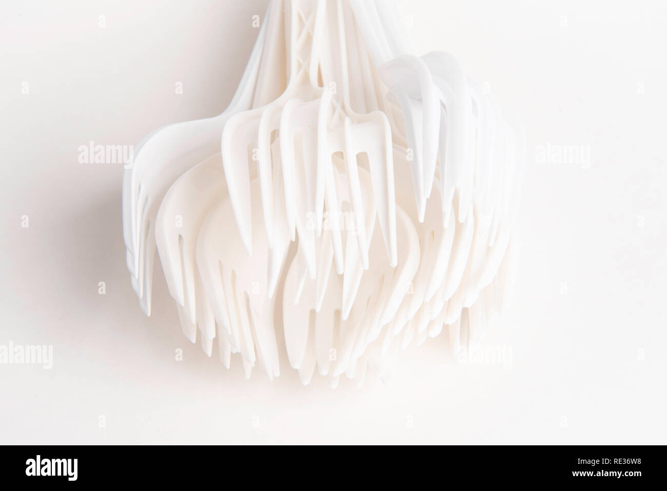 A bunch of white disposable single-use plastic forks commonly available ...