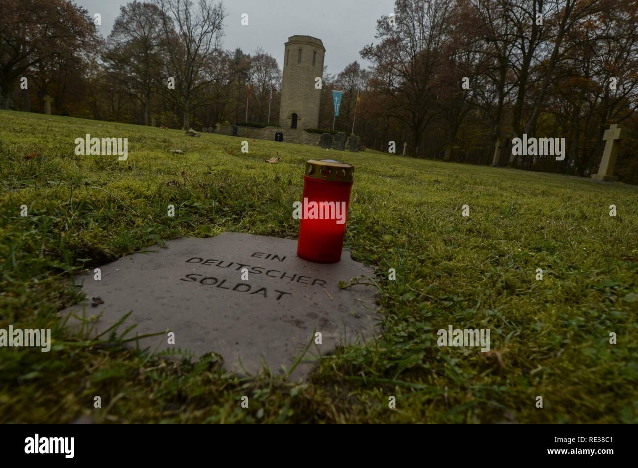 A candle remains lit on top of a grave marker of an unknown German ...