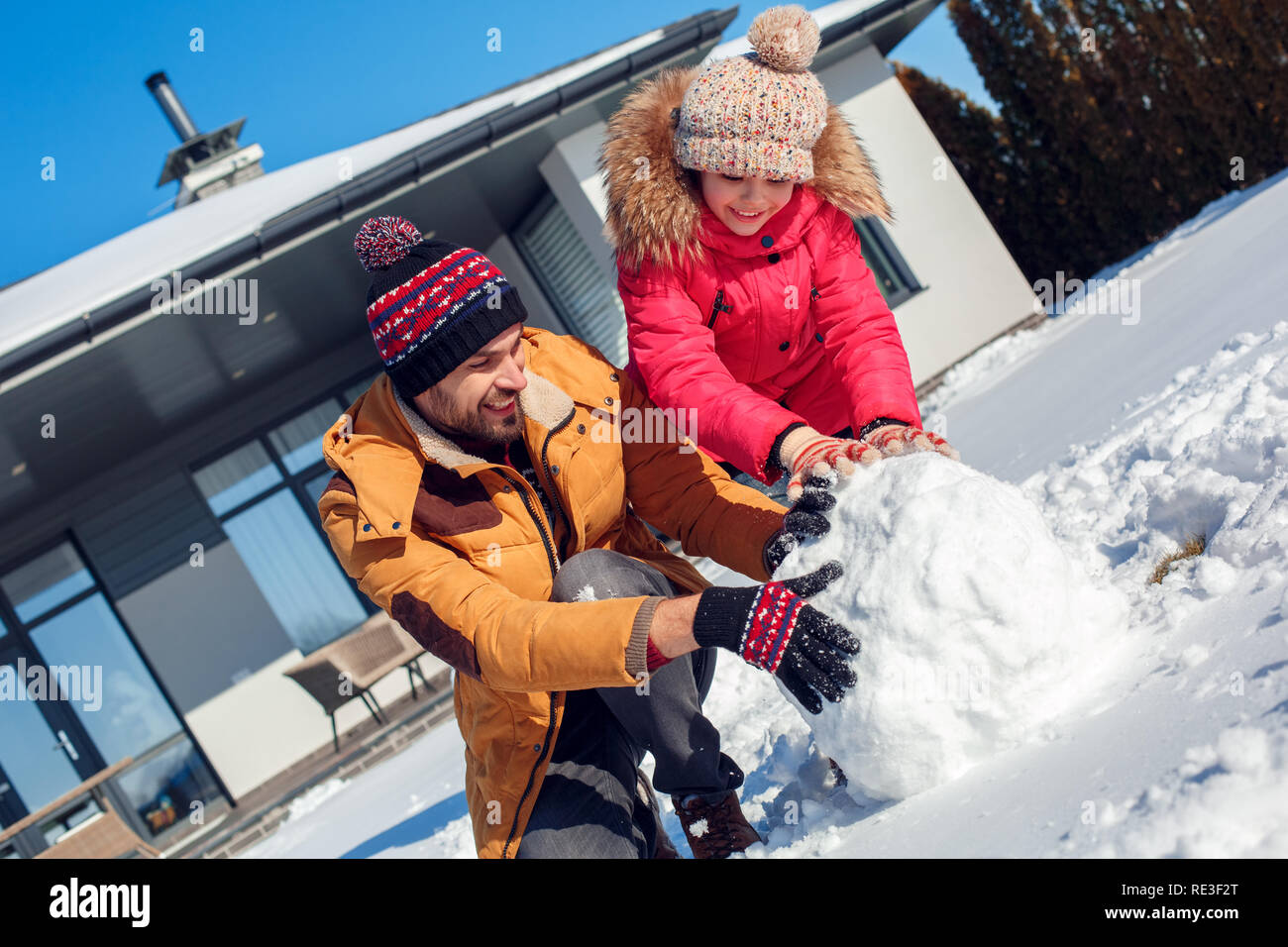 Winter vacation. Family time outdoors near hose rolling snowball for ...
