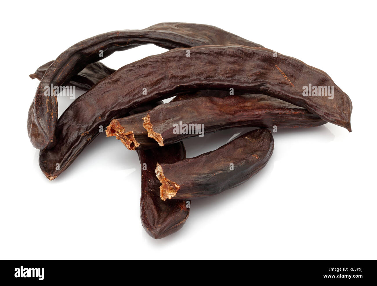 Ripe carob pods isolated on white background Stock Photo - Alamy