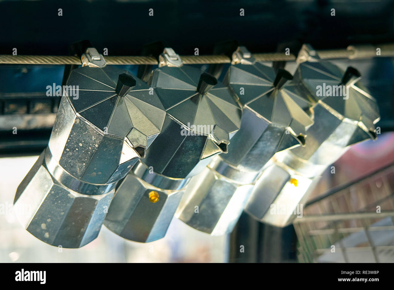 A line of stove-top moka pots hanging up in a small unique mobile ...
