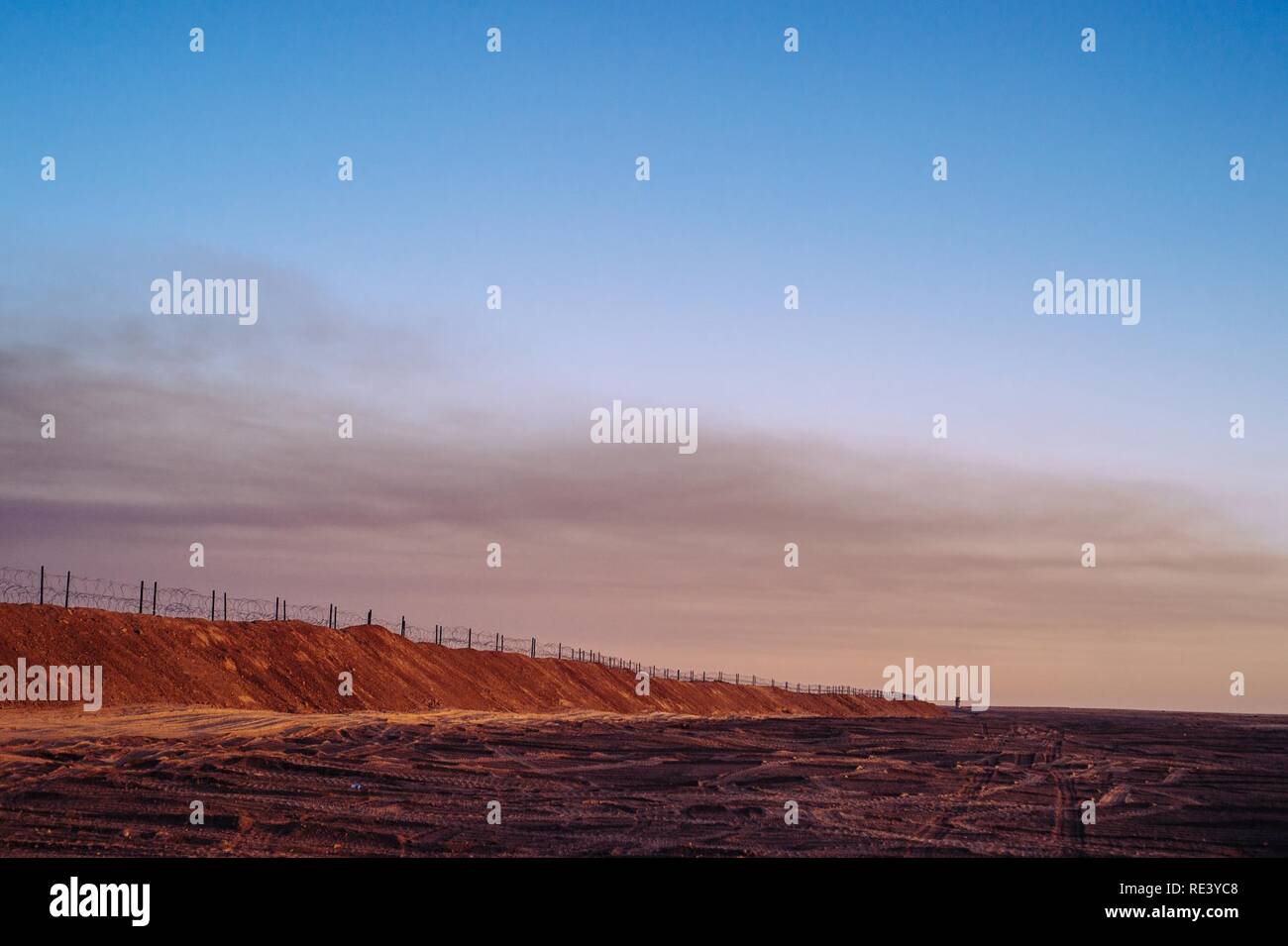 The sun sets on the perimeter berm at Qayyarah West Airfield, Iraq, Nov ...