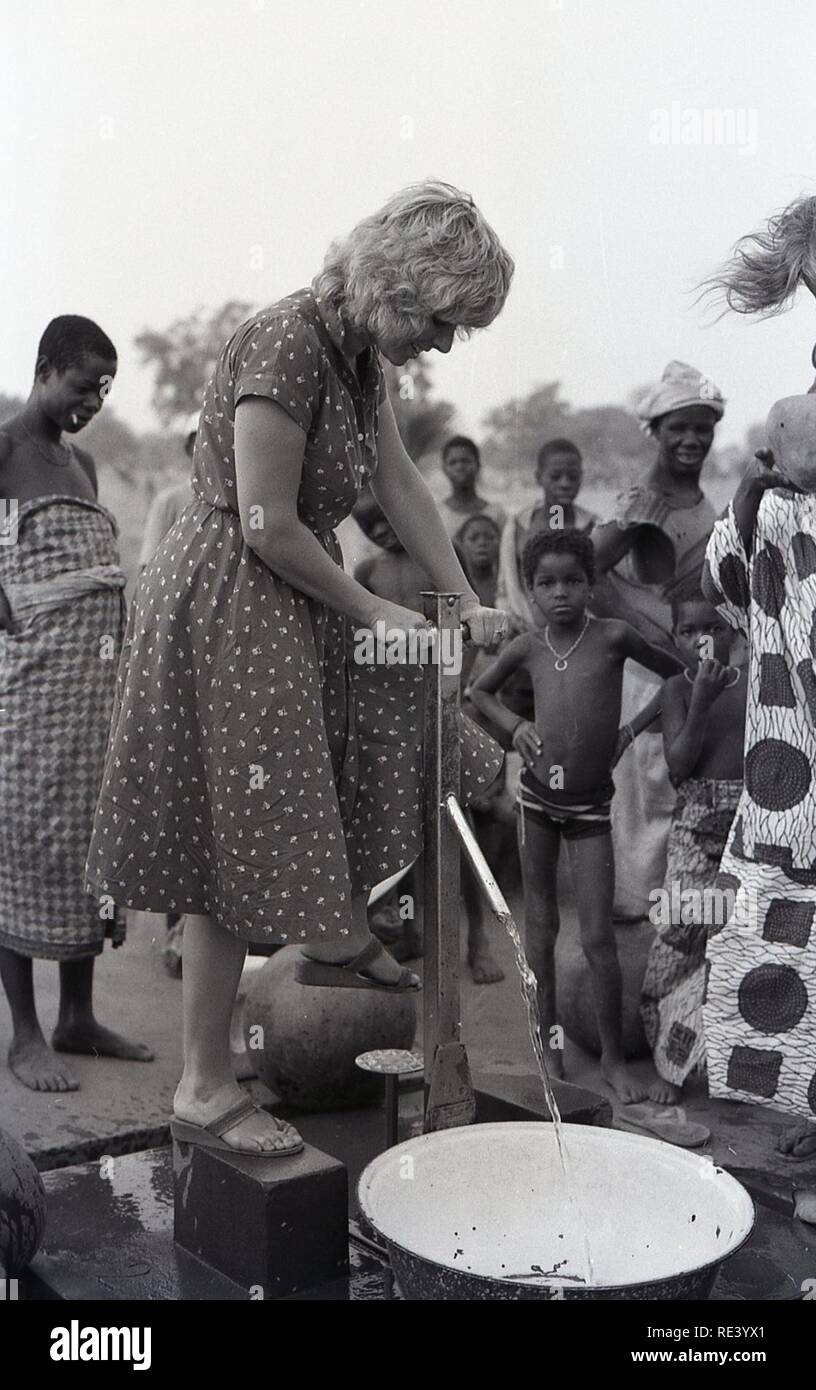 WOMAN PUMPING WATER FROM A WELL, WHILE OTHERS WATCH Stock Photo - Alamy