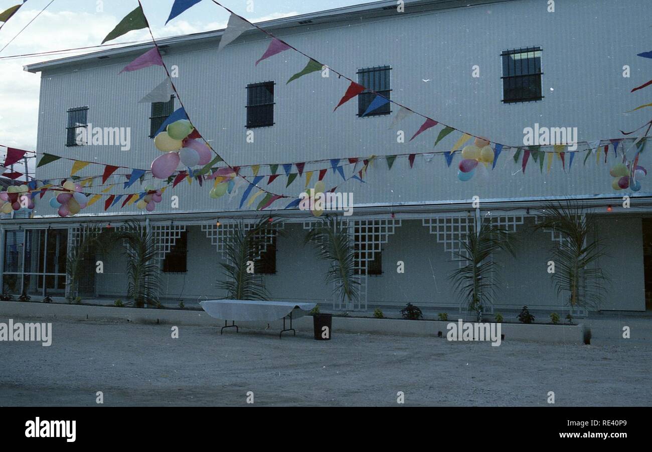 BUILDING OUTSIDE DECORATED WITH BALLOONS AND FLAG PENNANTS. TABLE ...
