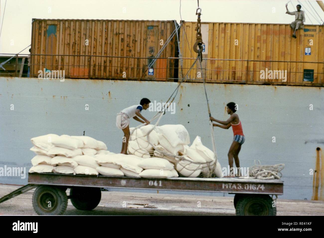 TWO MEN FILLING CARGO NET WITH SANDBAGS Stock Photo - Alamy