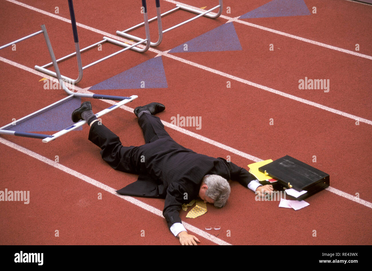 Mature businessman fallen over hurdle on running track, USA Stock Photo ...