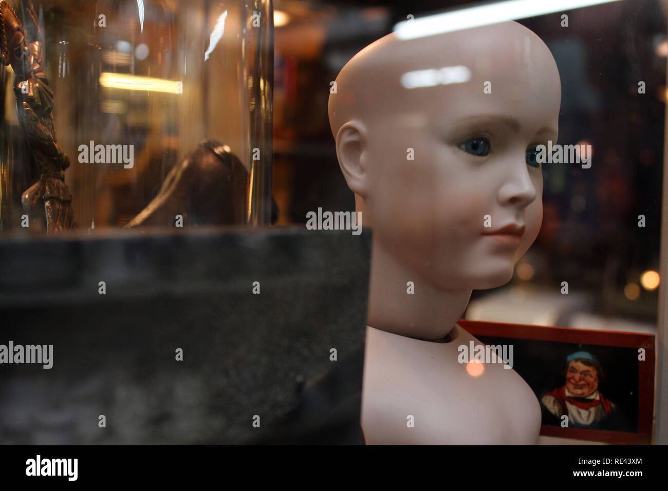 Doll and other objects displayed on a glass cabinet vintage shop en ...