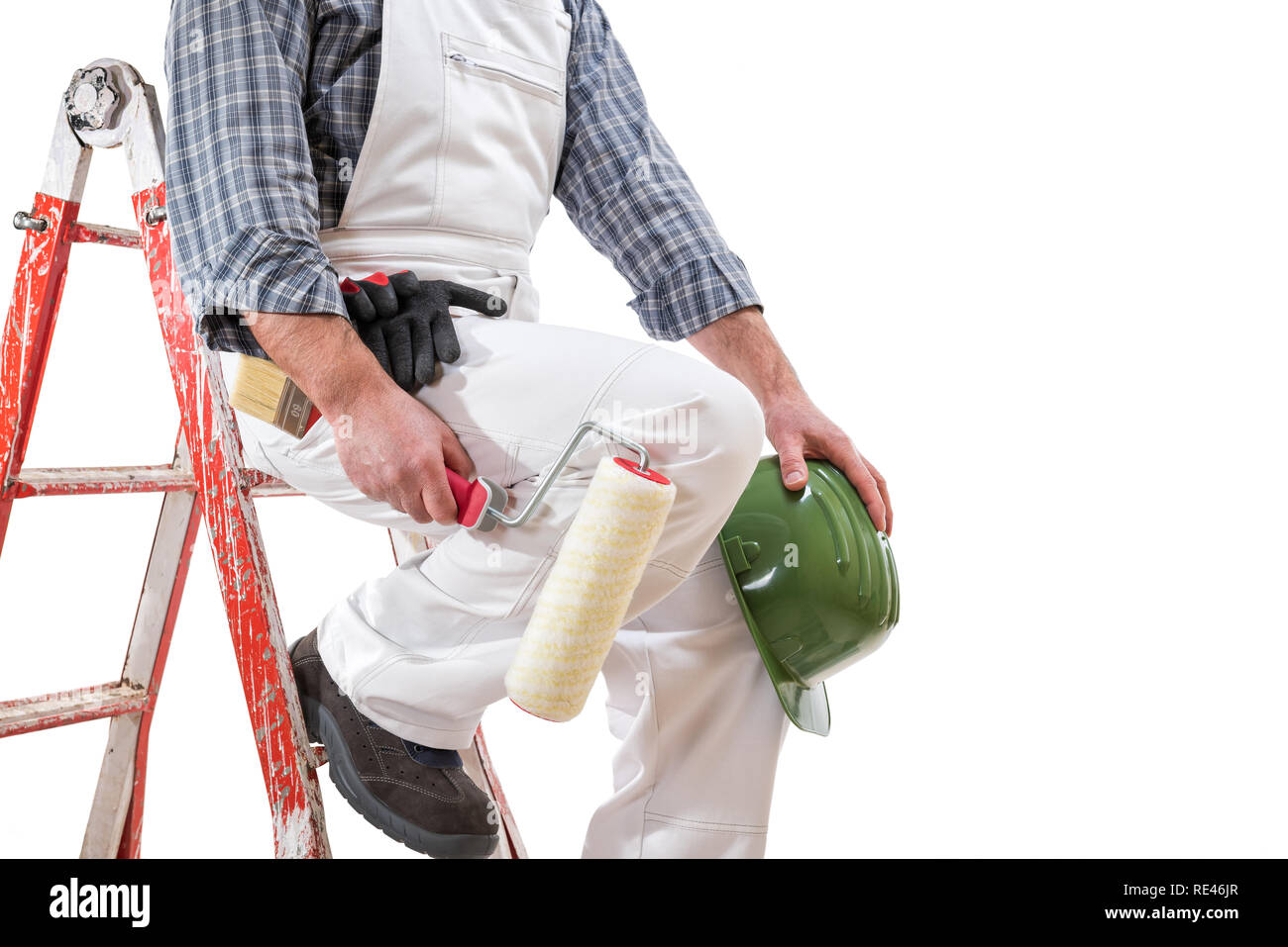 House painter worker on the ladder with white work overalls, keeps the ...