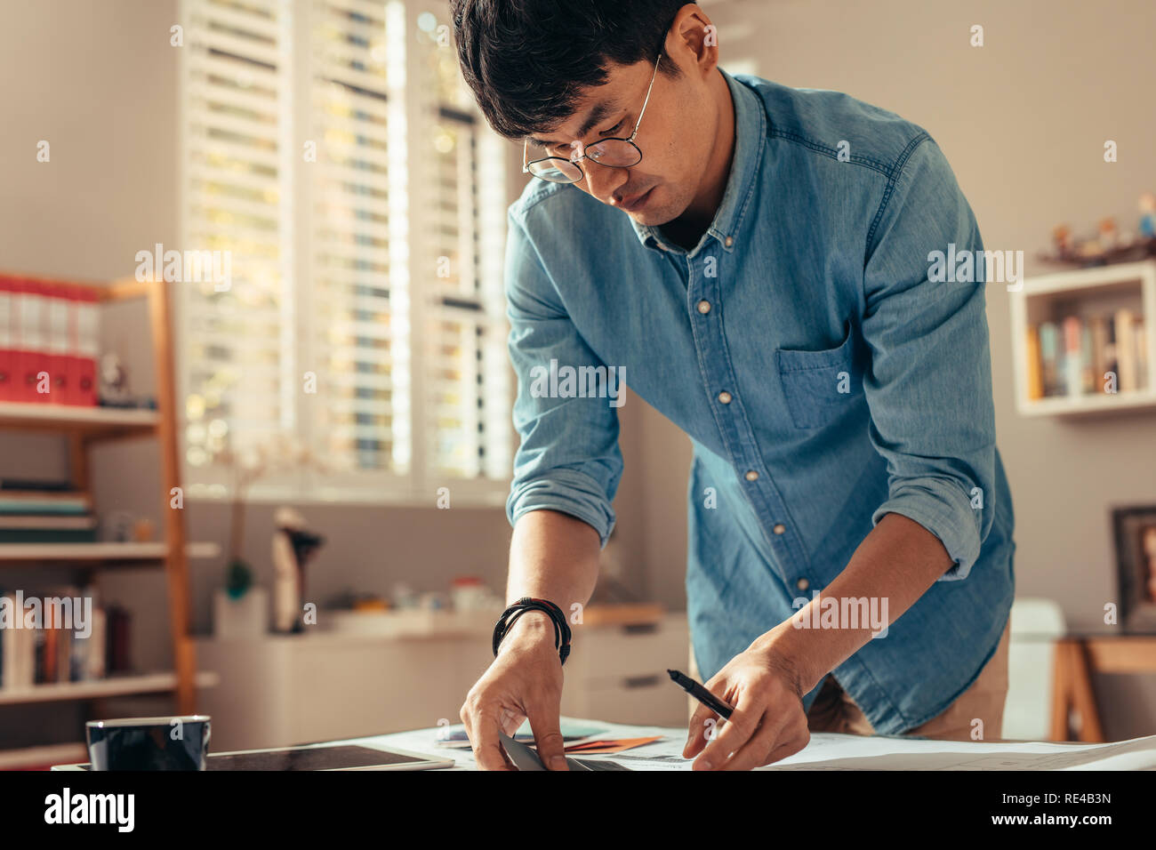 Designer choosing color for interior while working in office. Asian man ...