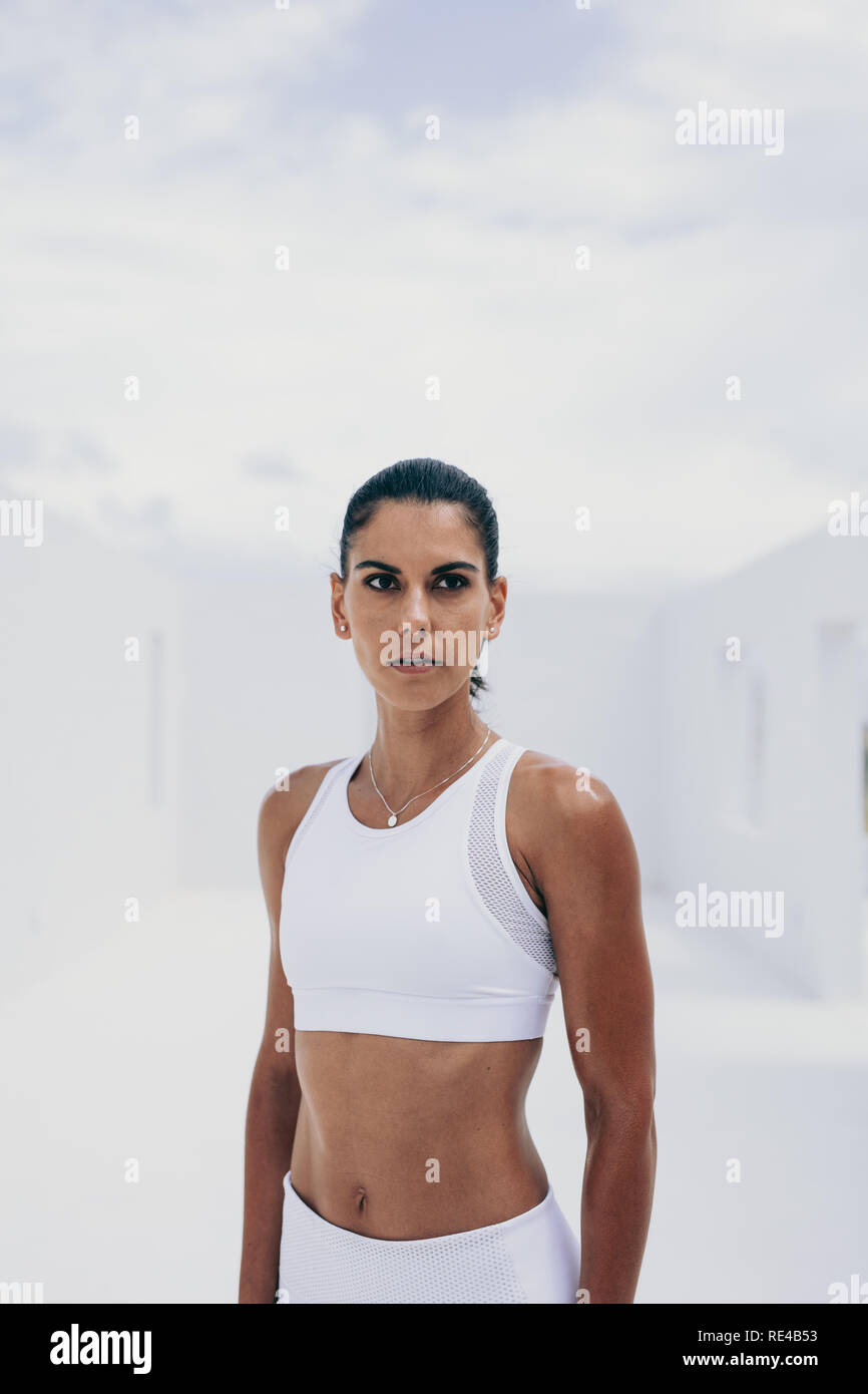 Woman in fitness wear standing and looking away. fitness woman looking ...