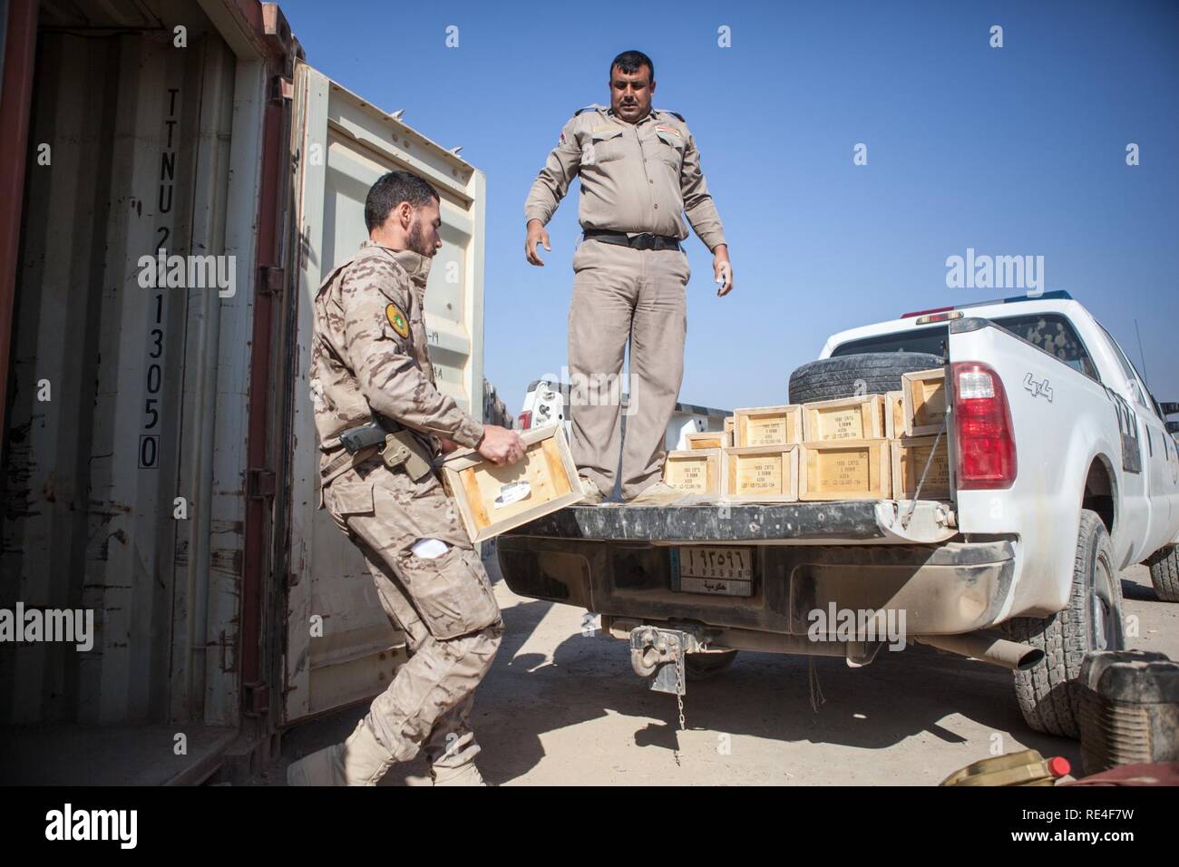 A Spanish army officer and Iraqi security forces soldier load ...