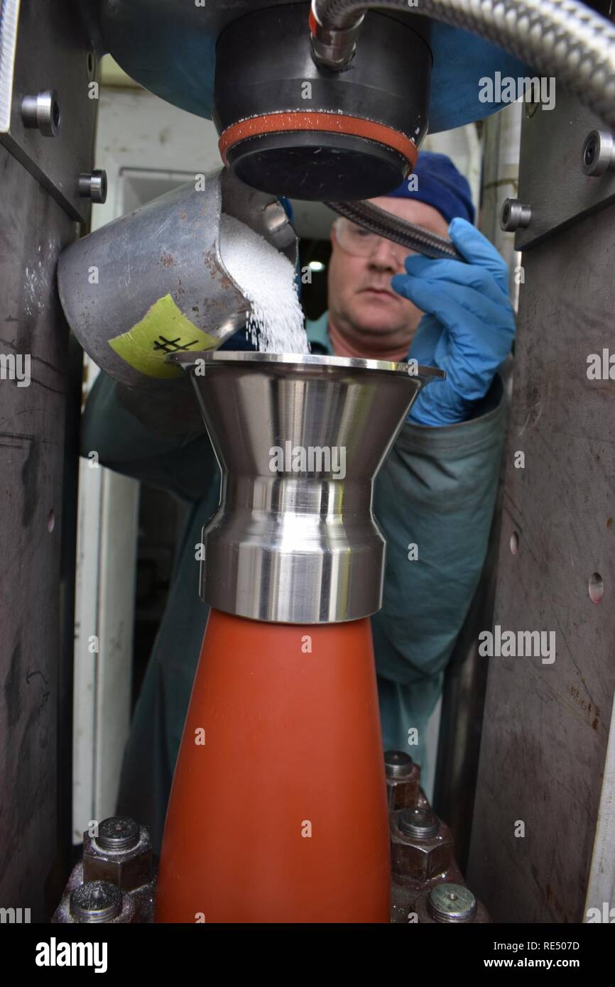 A Crane Army Ammunition Activity explosives operator adds explosive ...