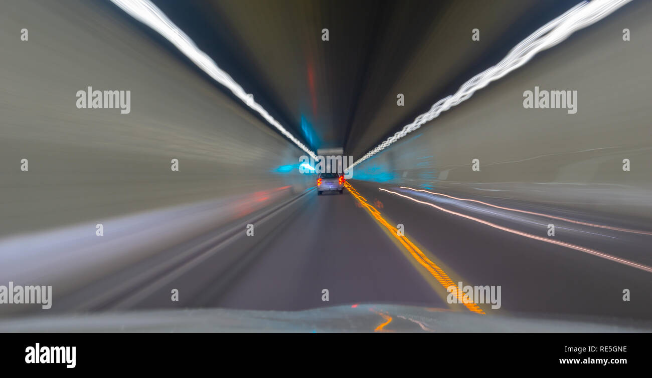 Transport abstract vehicle lights traveling through darkened tunnel ...