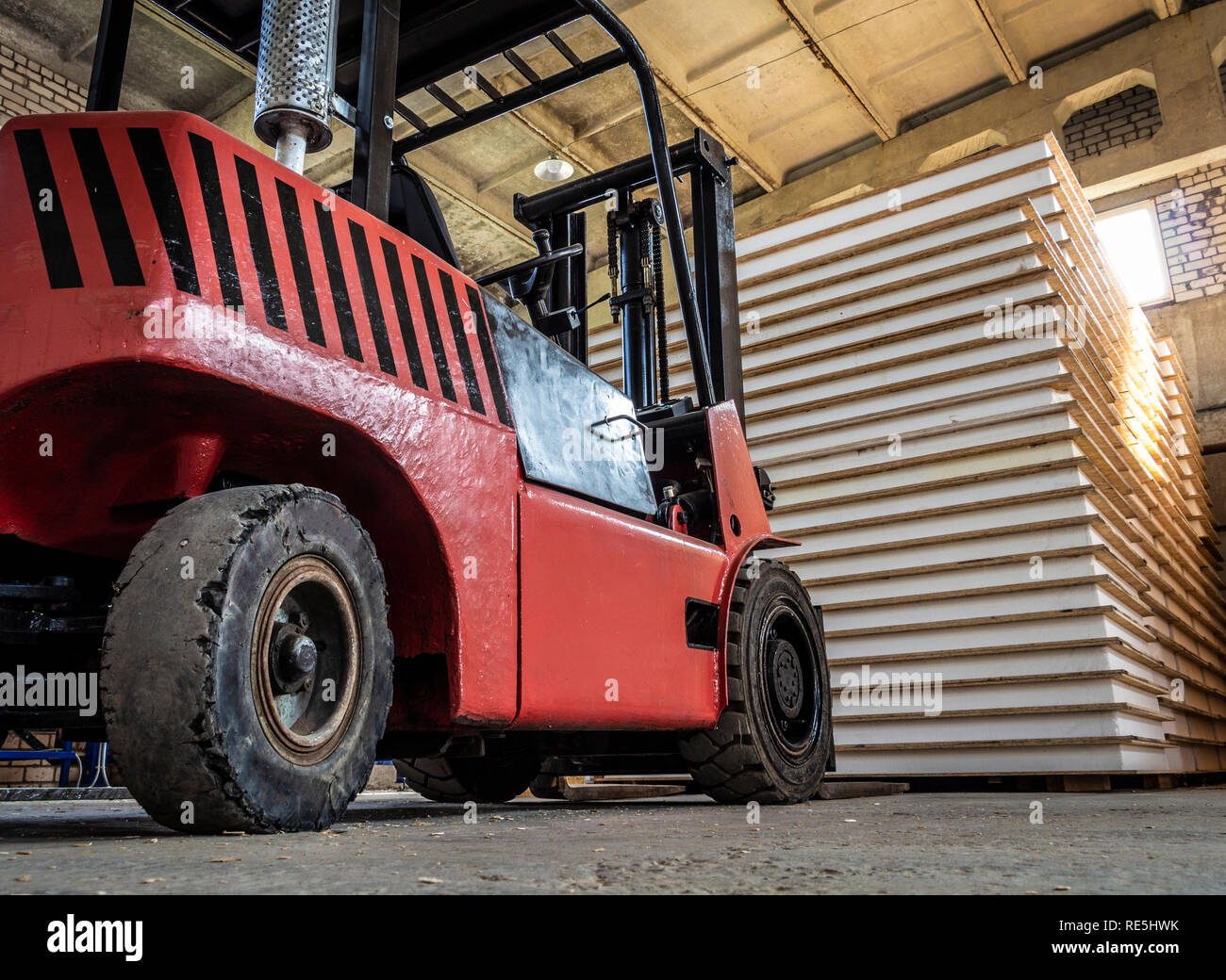 Orange forklift working on a warehouse of construction panels Stock ...
