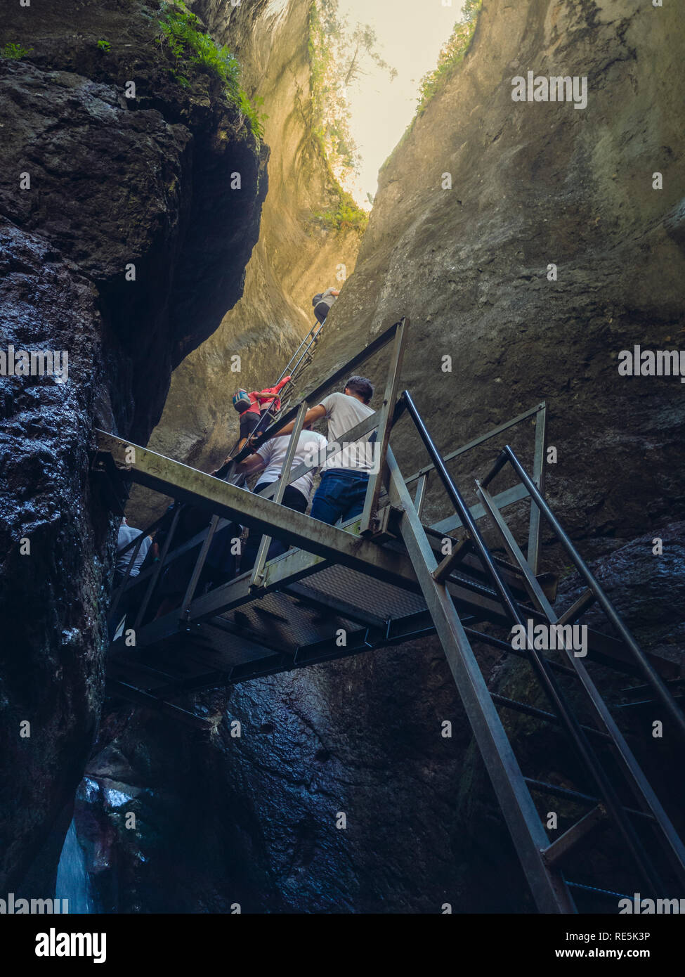 Tourists climb a ladder against the steep rocky walls of the Seven ...