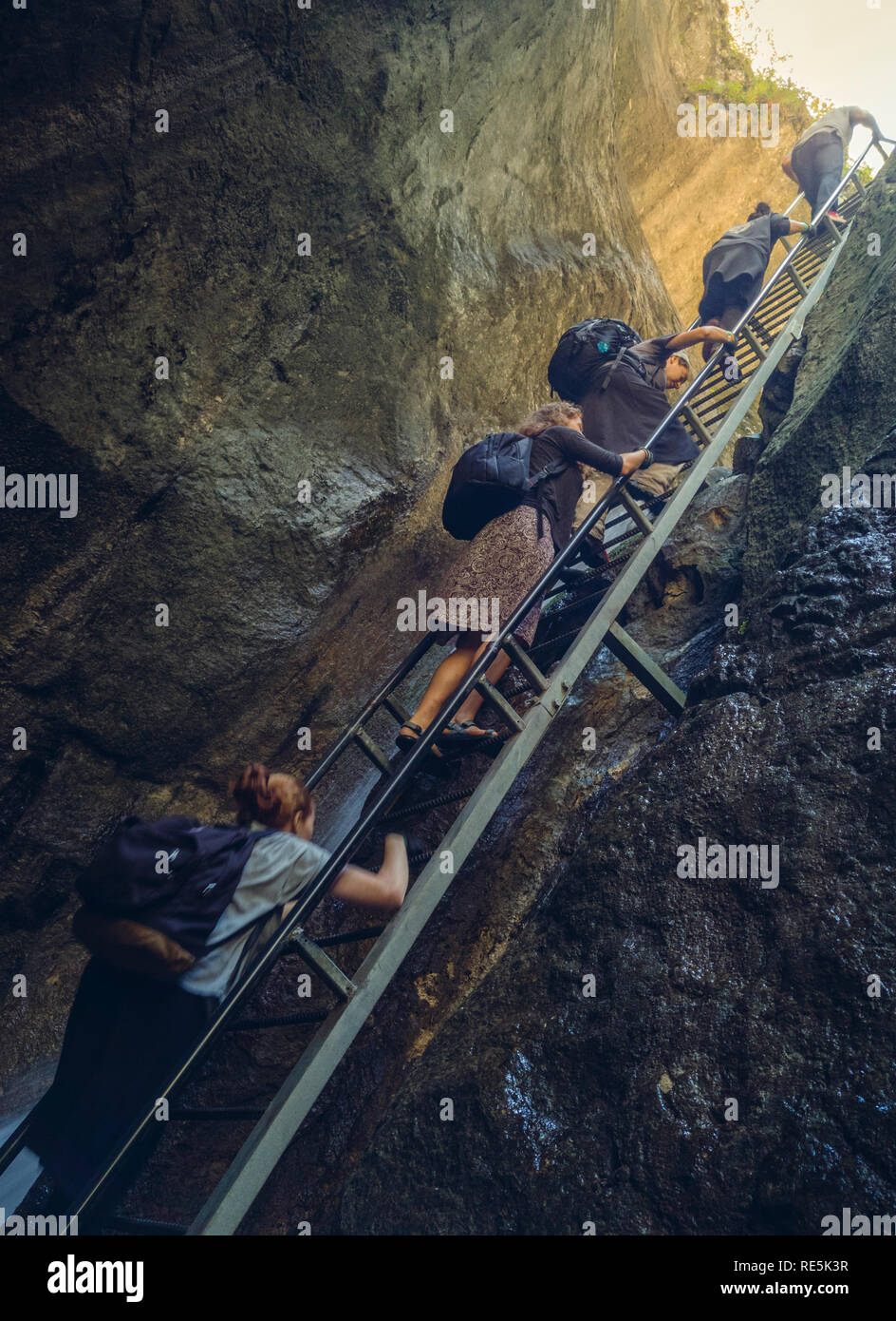 Tourists climb a ladder against the steep rocky walls of the Seven ...