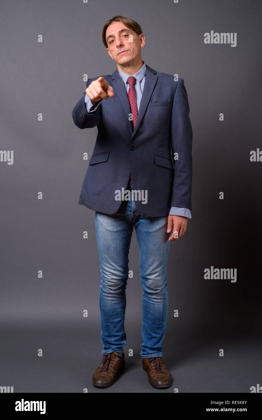 Full length shot of mature handsome Italian businessman pointing finger ...