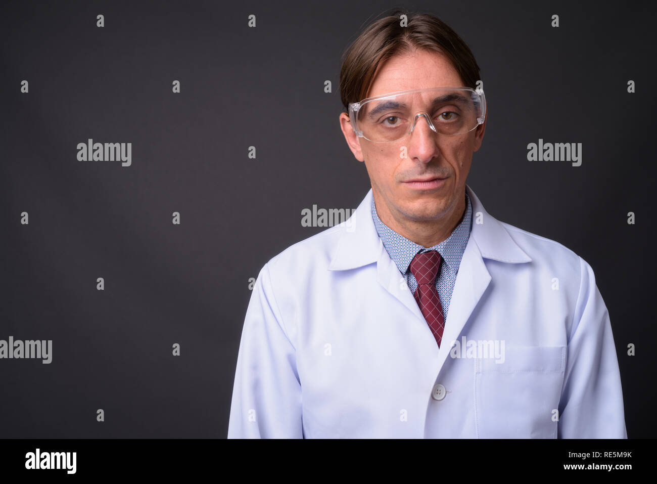 Mature handsome Italian man doctor wearing protective glasses Stock ...