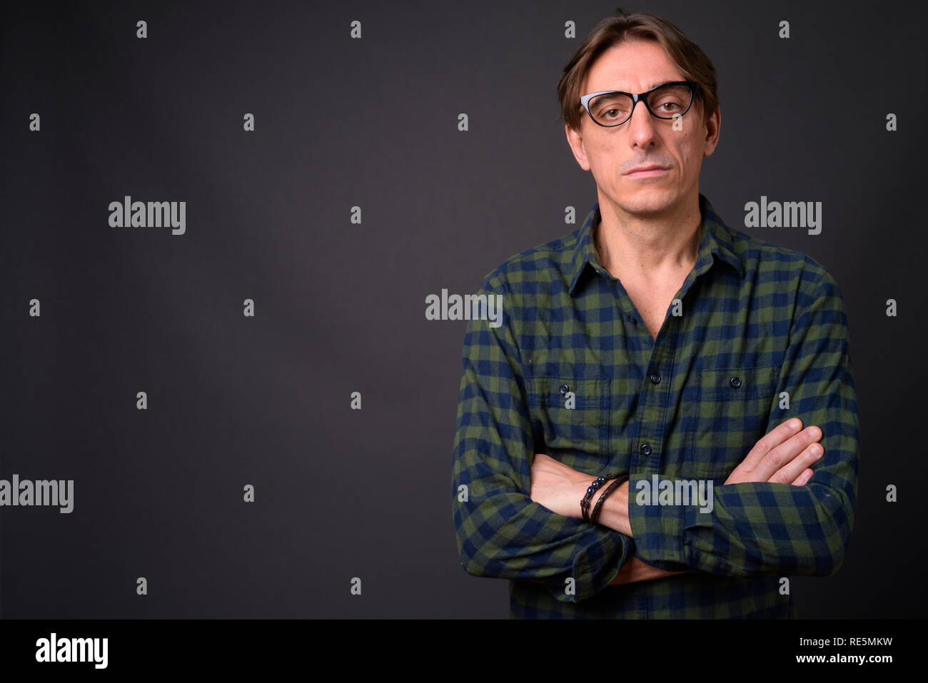 Mature handsome Italian man against gray background Stock Photo - Alamy