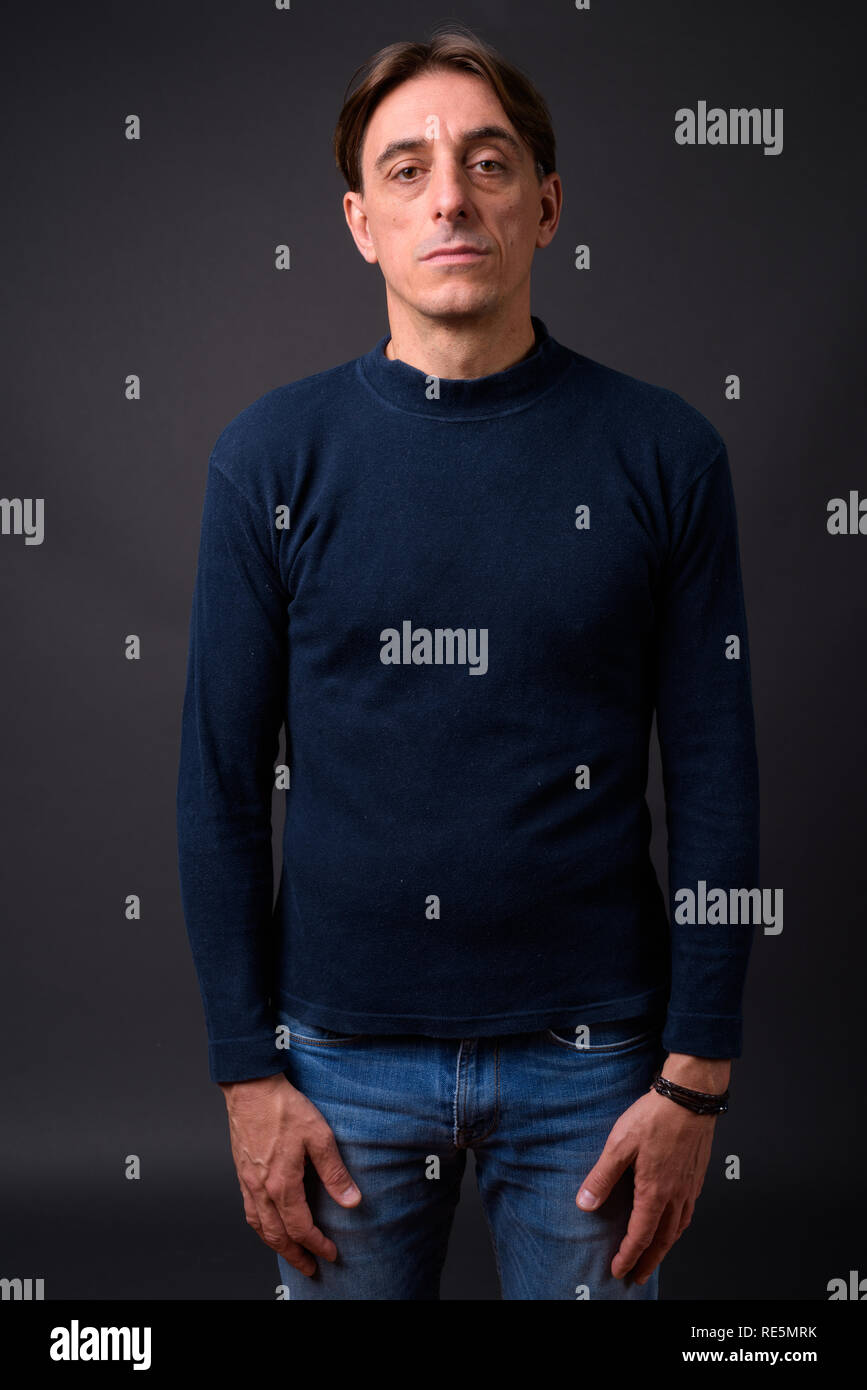 Mature handsome Italian man against gray background Stock Photo - Alamy