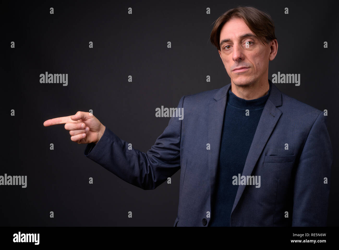 Mature handsome Italian businessman showing copy space Stock Photo - Alamy
