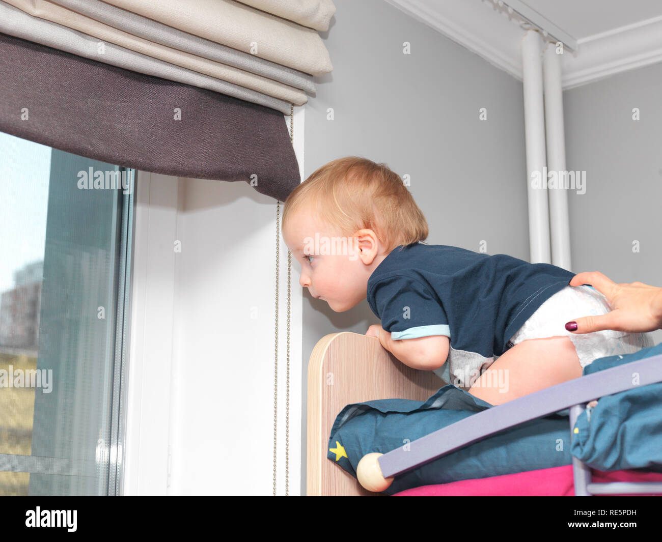 A little curious boy looking at the window after sleep, indoor shot ...