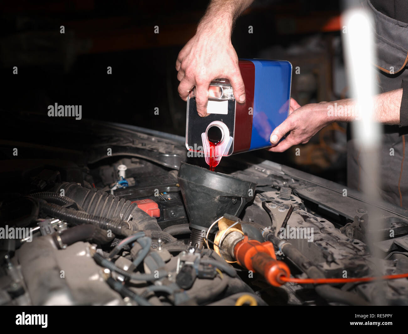 Hand of mechanic changing oil in a car engine, indoor close-up Stock ...