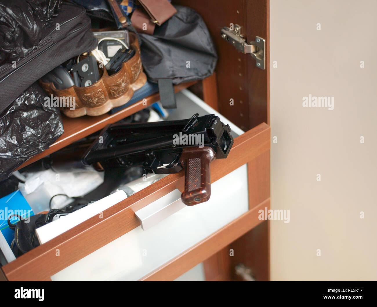 Close-up of a machine gun hidden in a wardrobe, concept of self ...