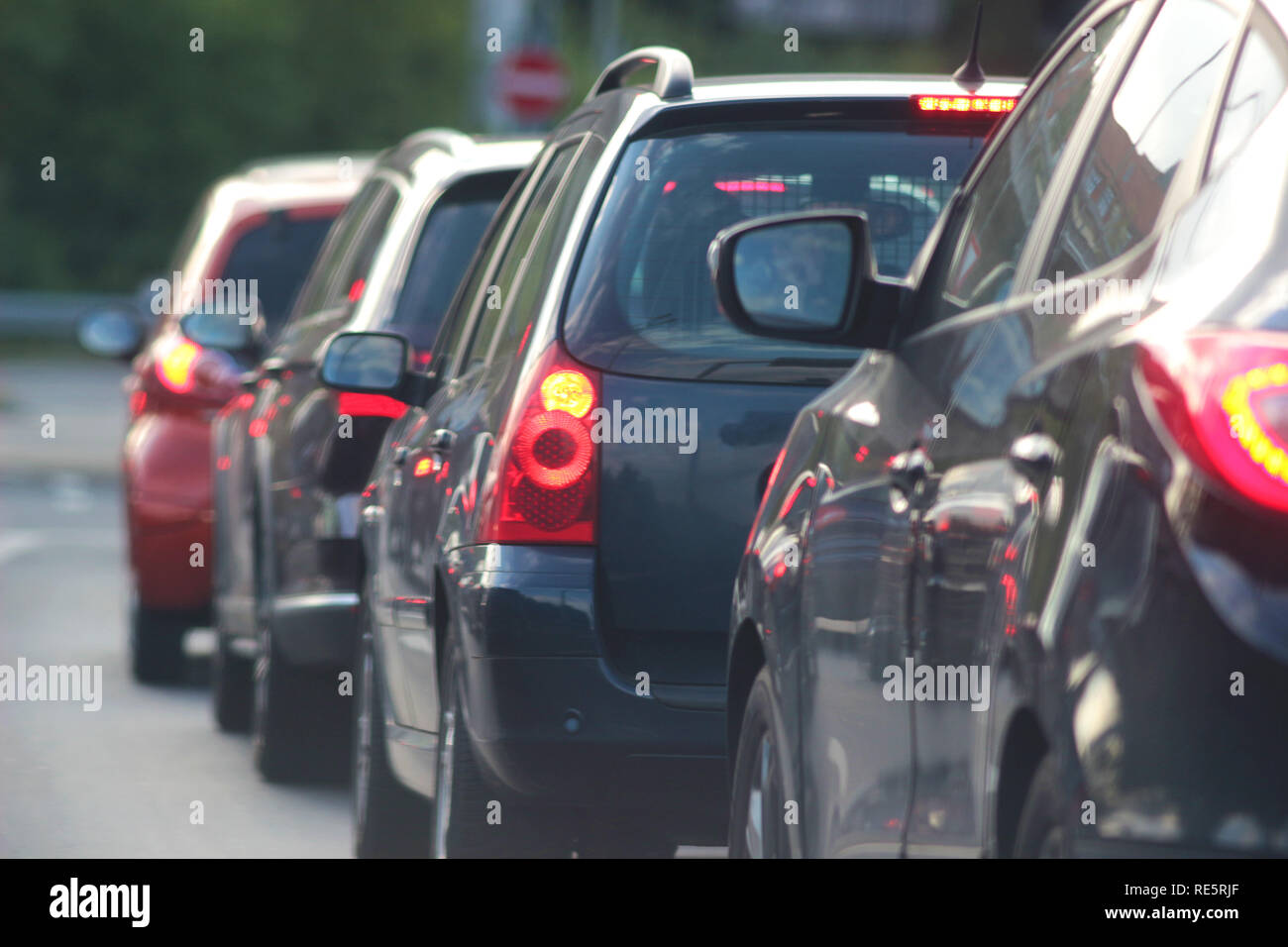 cars stopping in front of a red traffic light, with red lighted brake ...