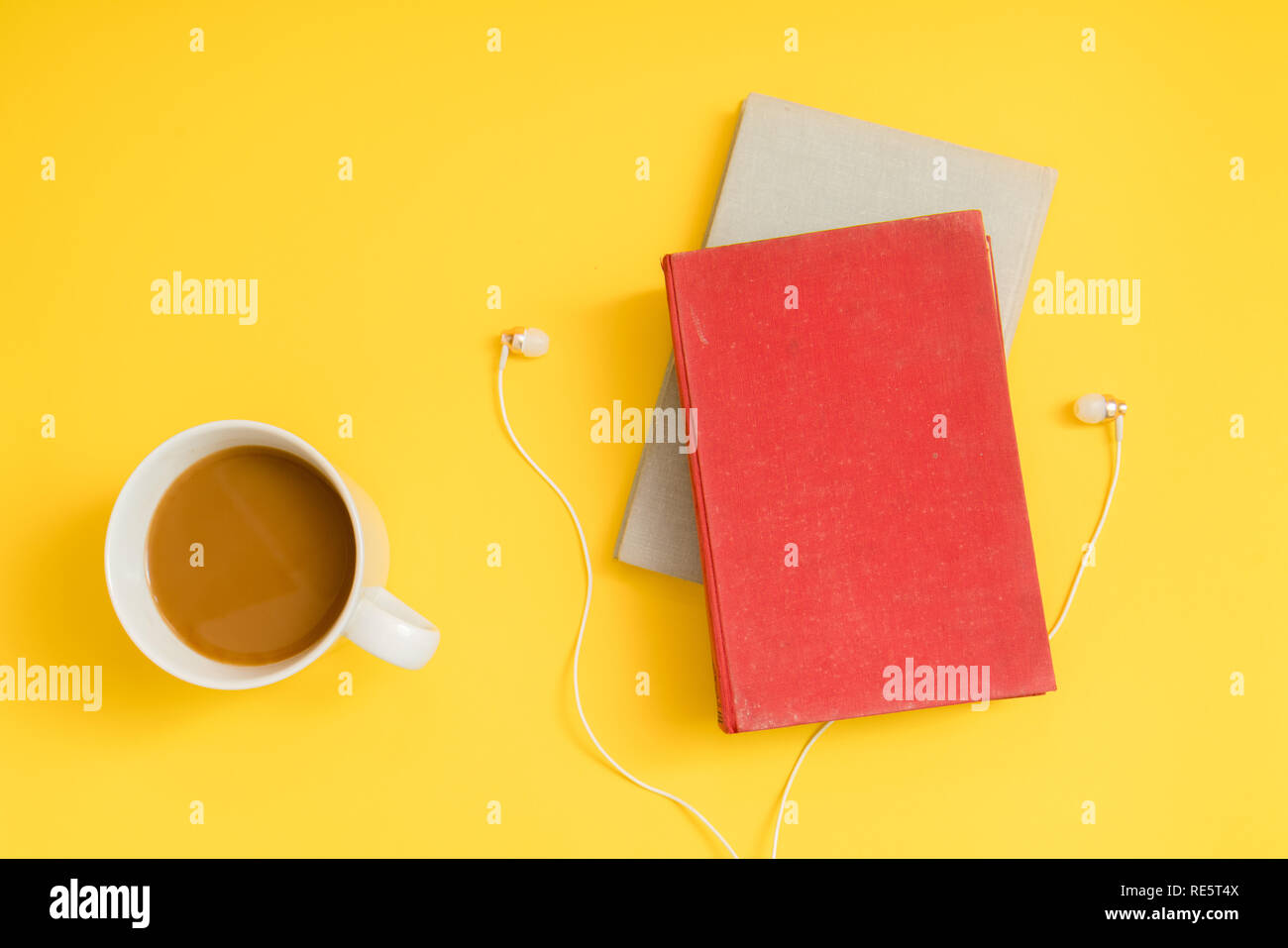 Audio book concept. Headphones, coffee and hard cover book over yellow ...