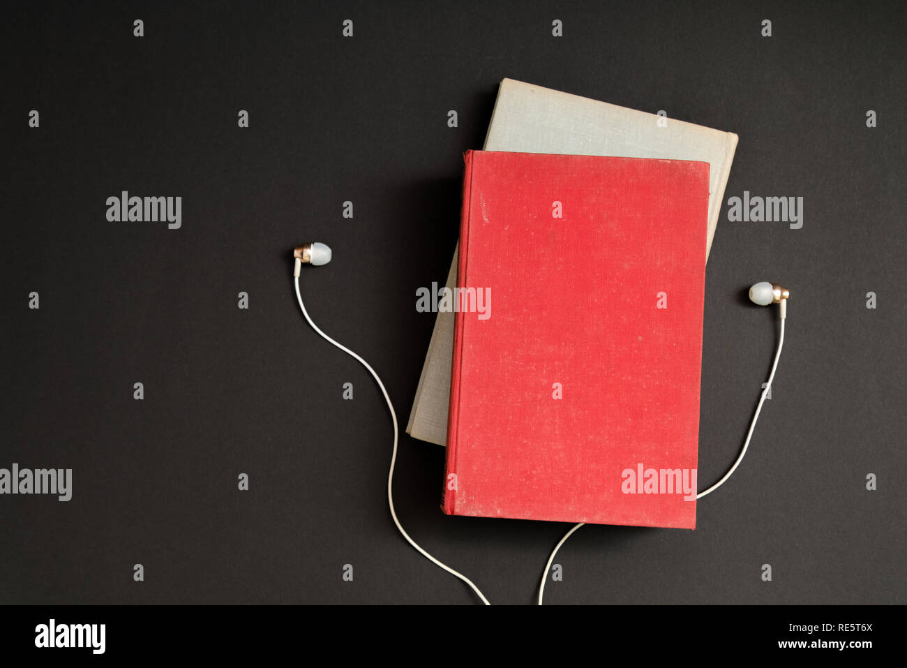 Audio book concept. Headphones and book over black table background ...