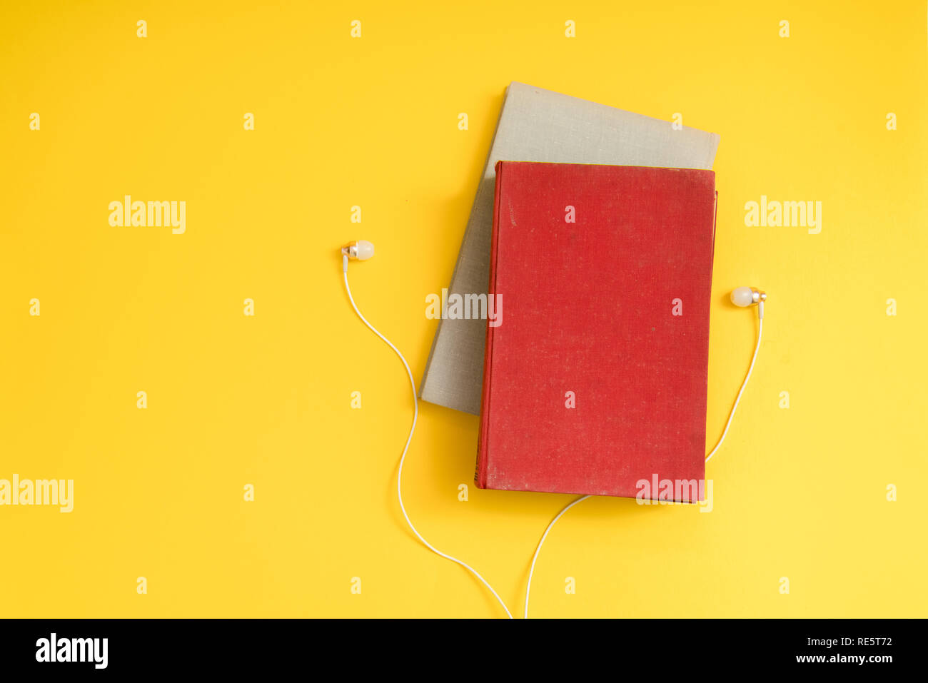 Audio book concept. Headphones and book over yellow table background ...