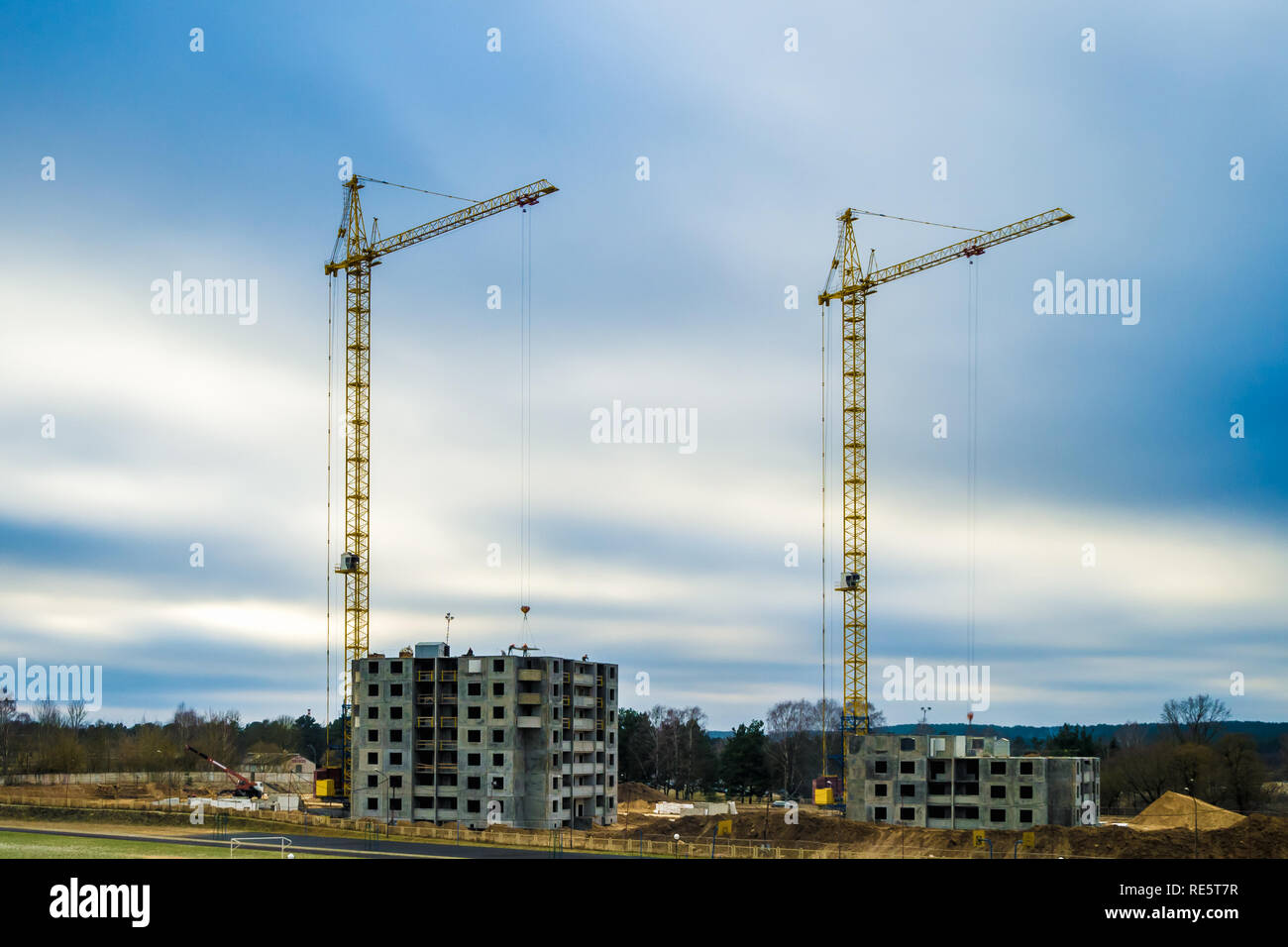 Tower cranes and unfinished multi-storey high near buildings under ...