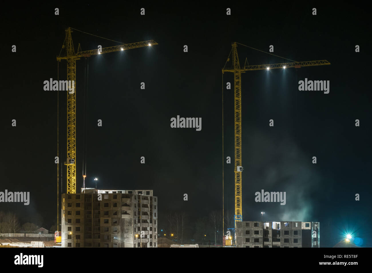Tower cranes and unfinished multi-storey high near buildings under ...
