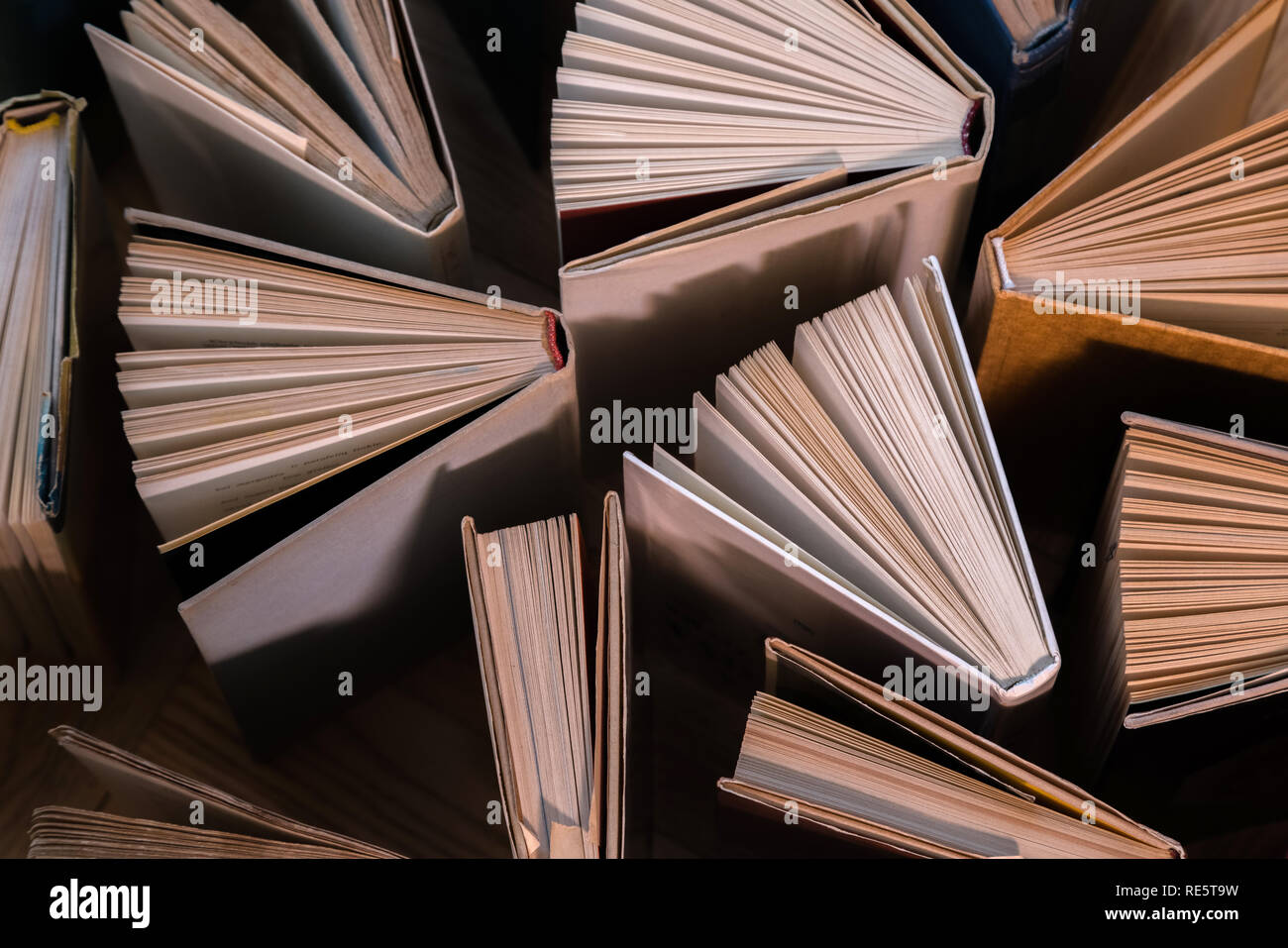 Old and used hardback books, text books seen from above on wooden floor ...