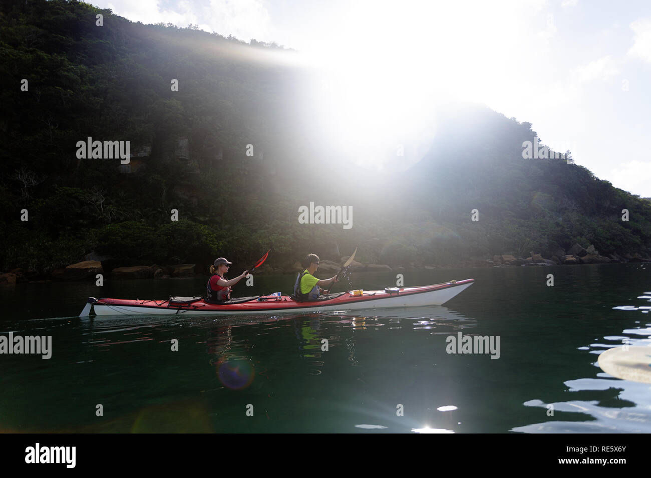 Woman and man paddle double kayak on sea, side view, Iriomote Island ...