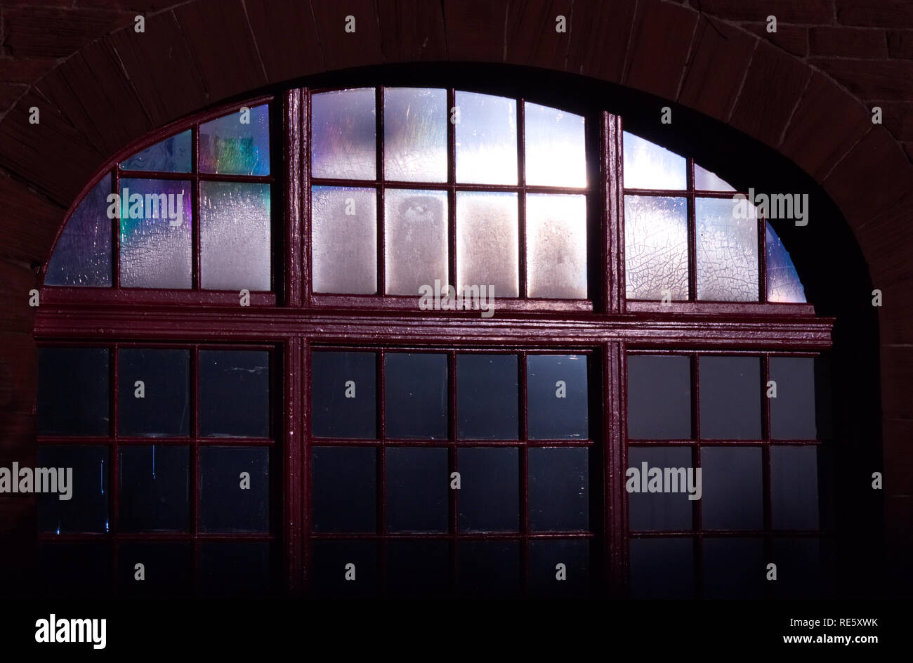 A photograph of a vintage dark window and the reflection of trees ...