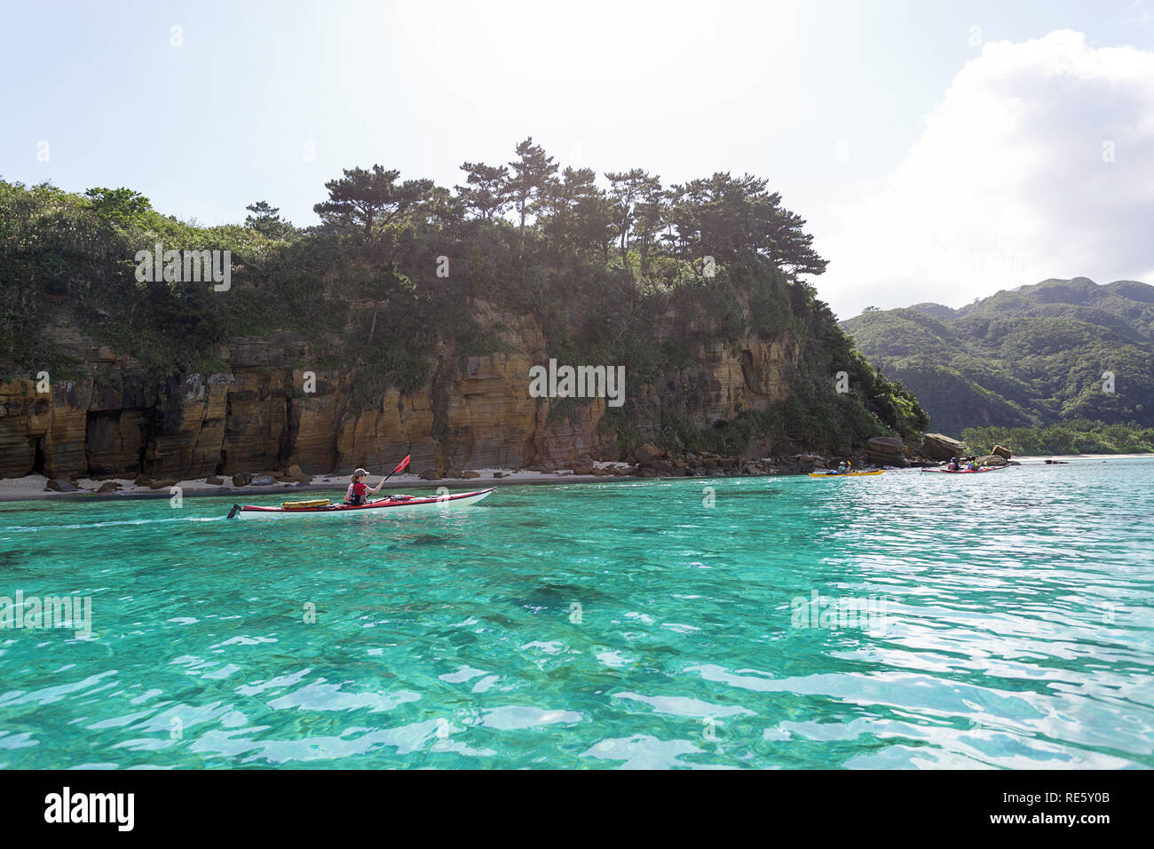 Group of kayakers on a kayaking expedition at tropical islands on a ...