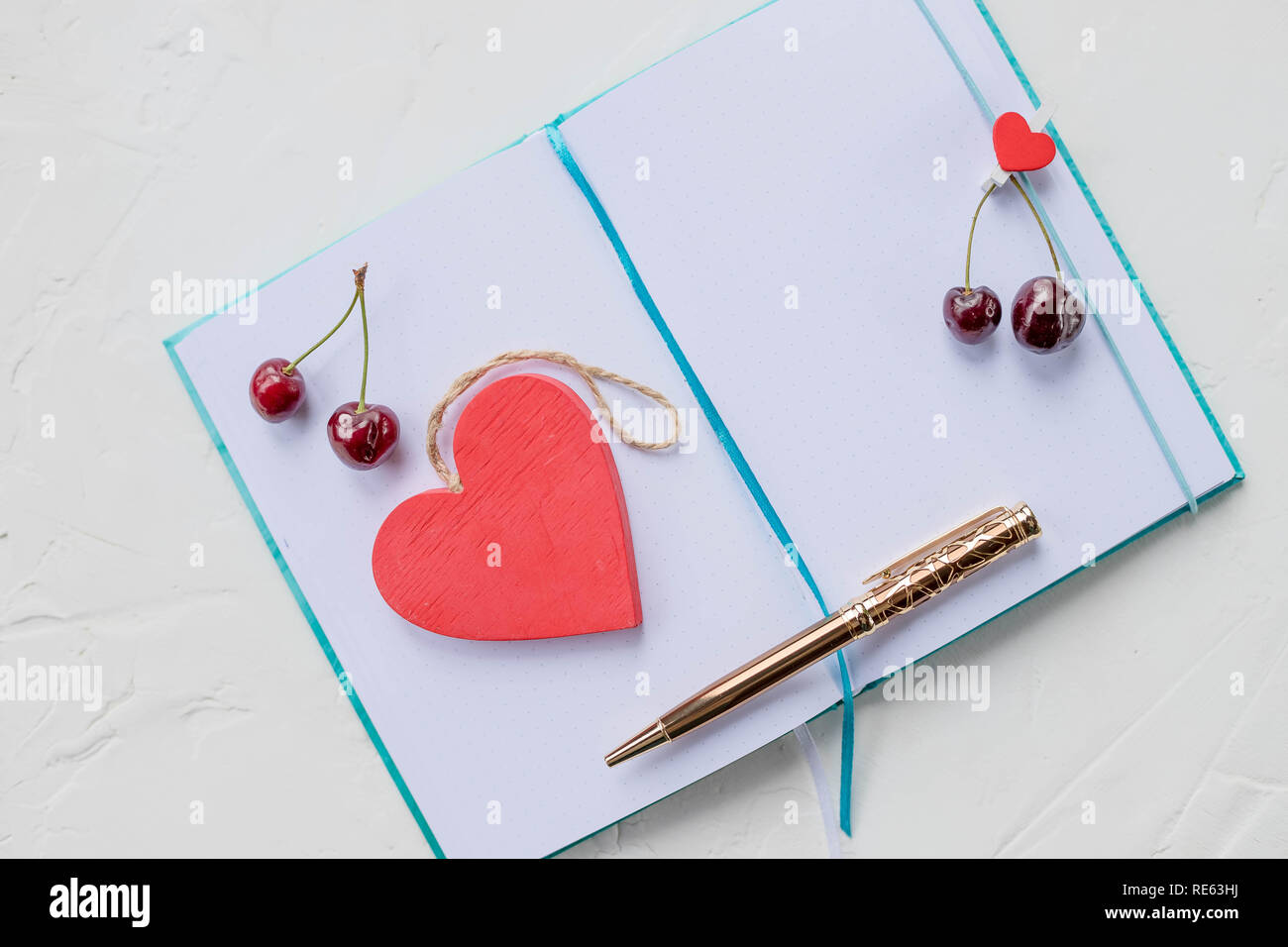 Hearts and cherry. Dreaming theme about love. An open notebook is on a ...