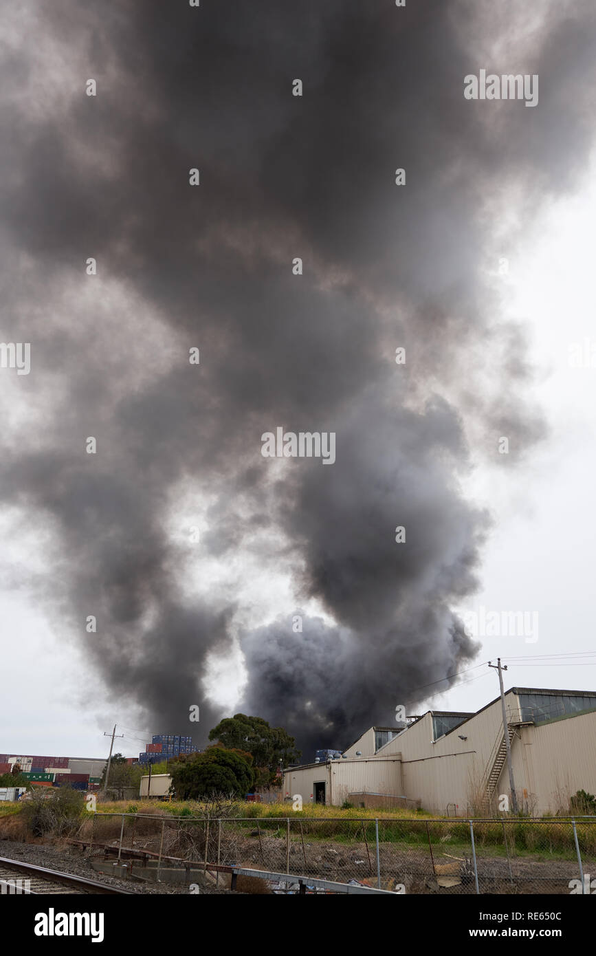Plumes of toxic smoke from an industrial fire rise up into the air ...