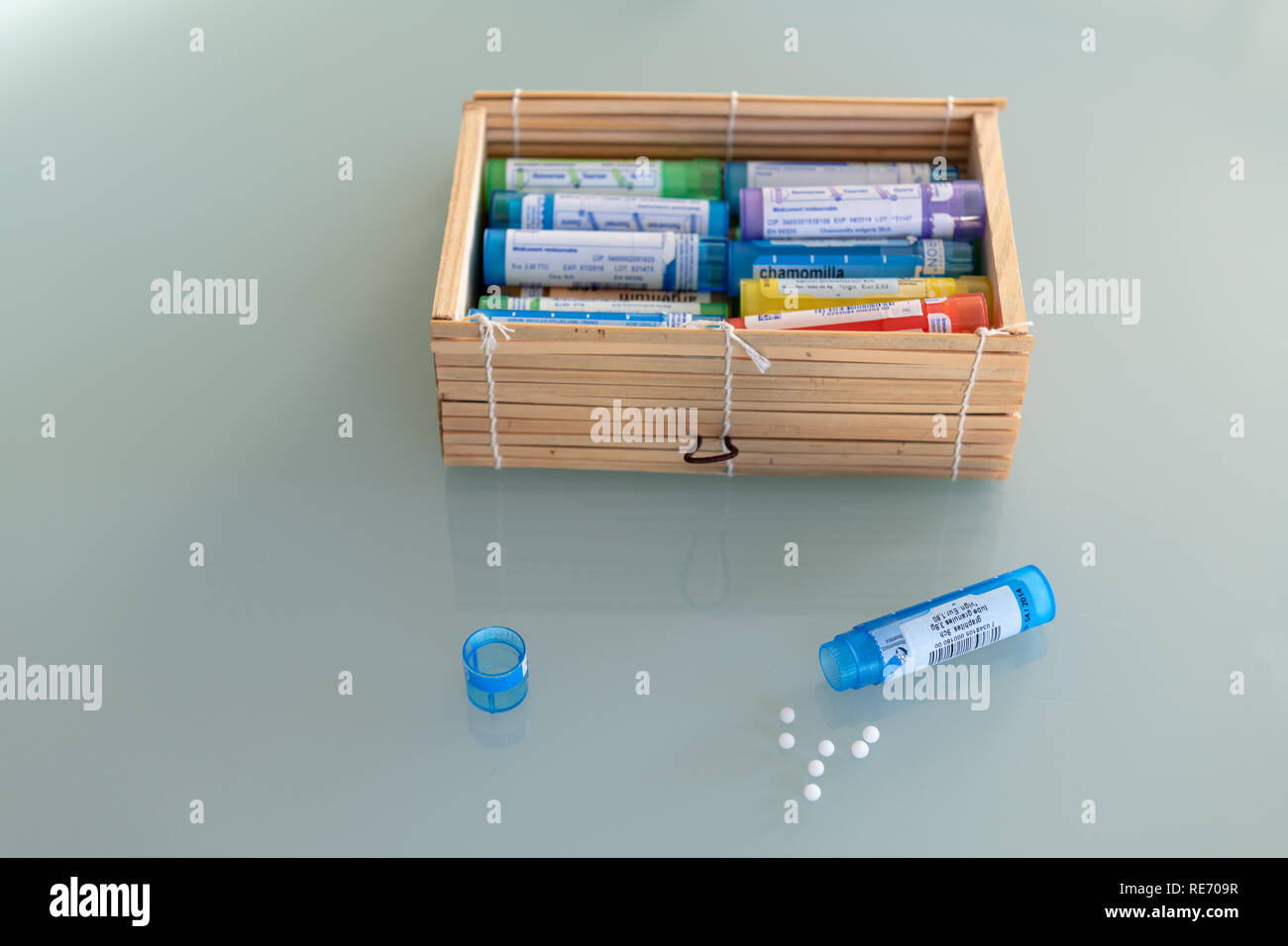 Homeopathic globules scattered around with their colored containers in ...