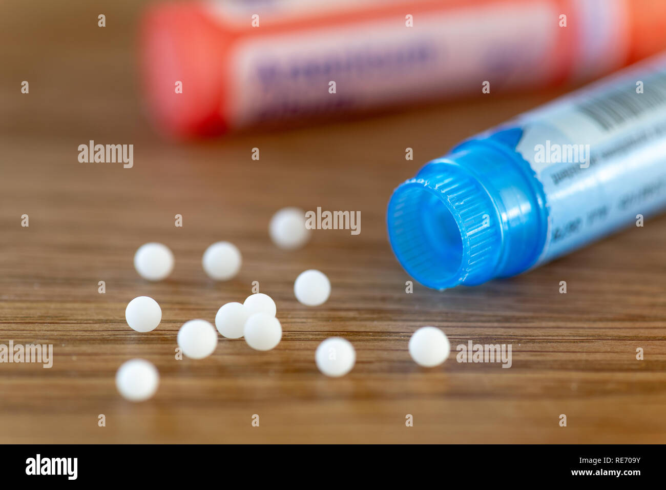 Homeopathic globules scattered around with their colored containers in ...